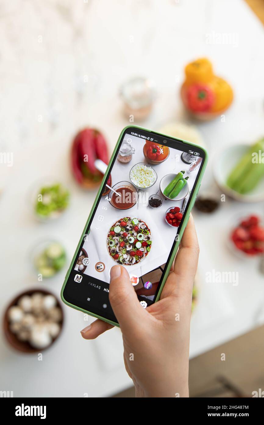 Woman taking photo of pizza made with cell phone Stock Photo - Alamy