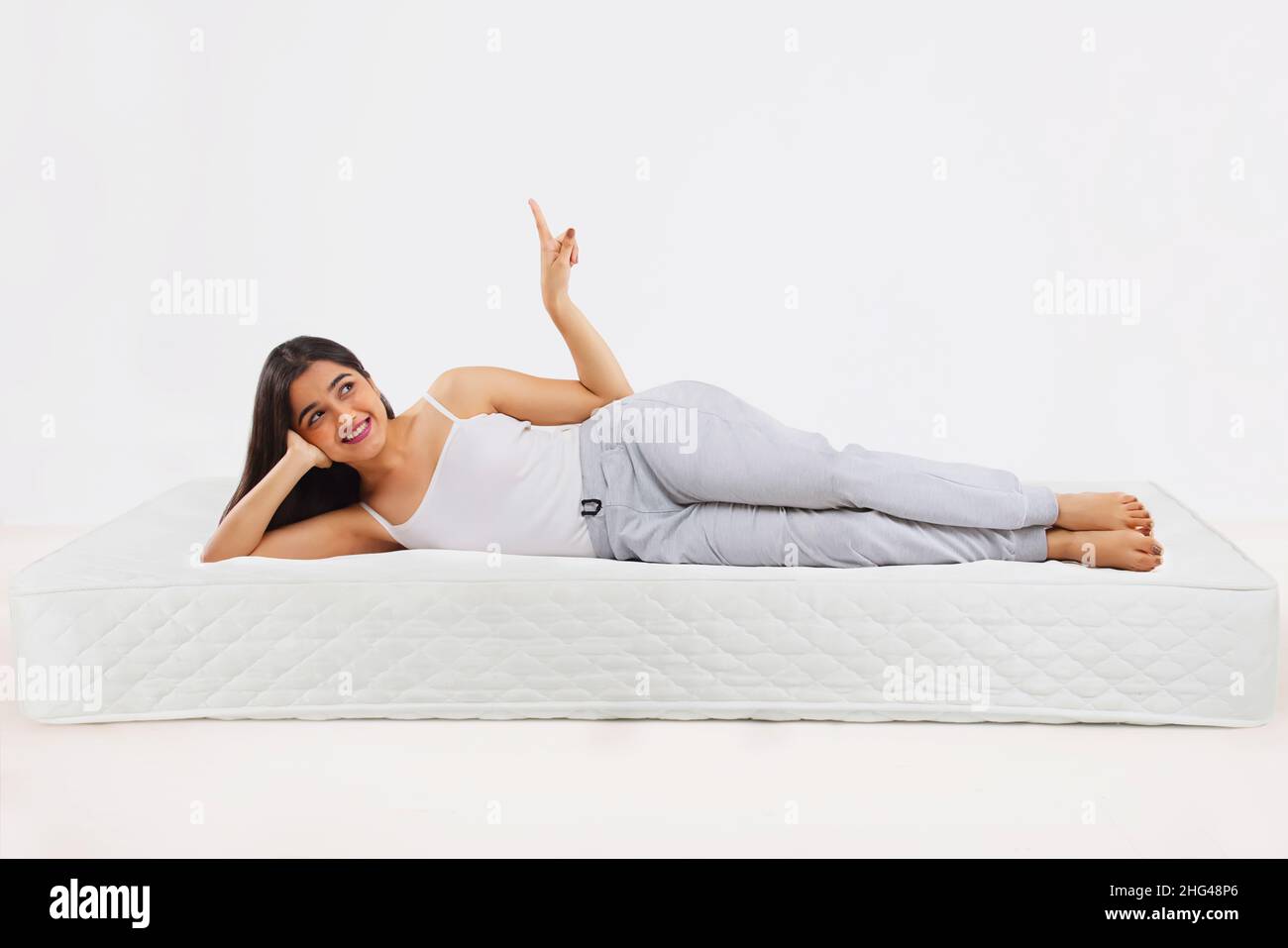 Young girl pointing up with her finger while lying on mattress Stock ...