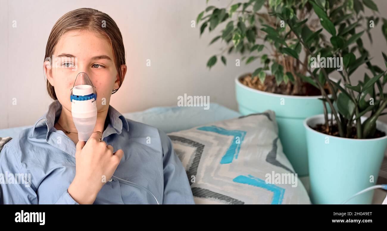 Teenage girl makes inhalation with a nebulizer equipment. Sick child ...