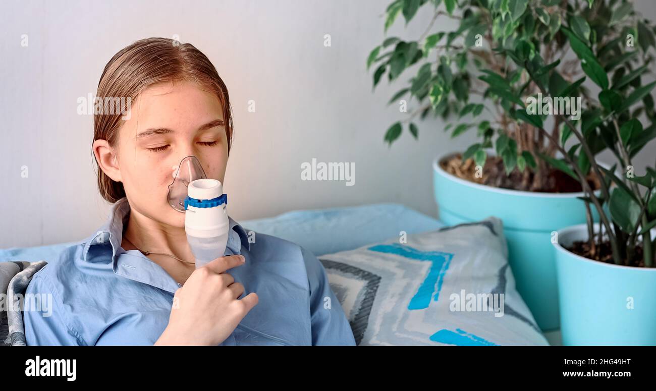 Teenage girl makes inhalation with a nebulizer equipment. Sick child ...