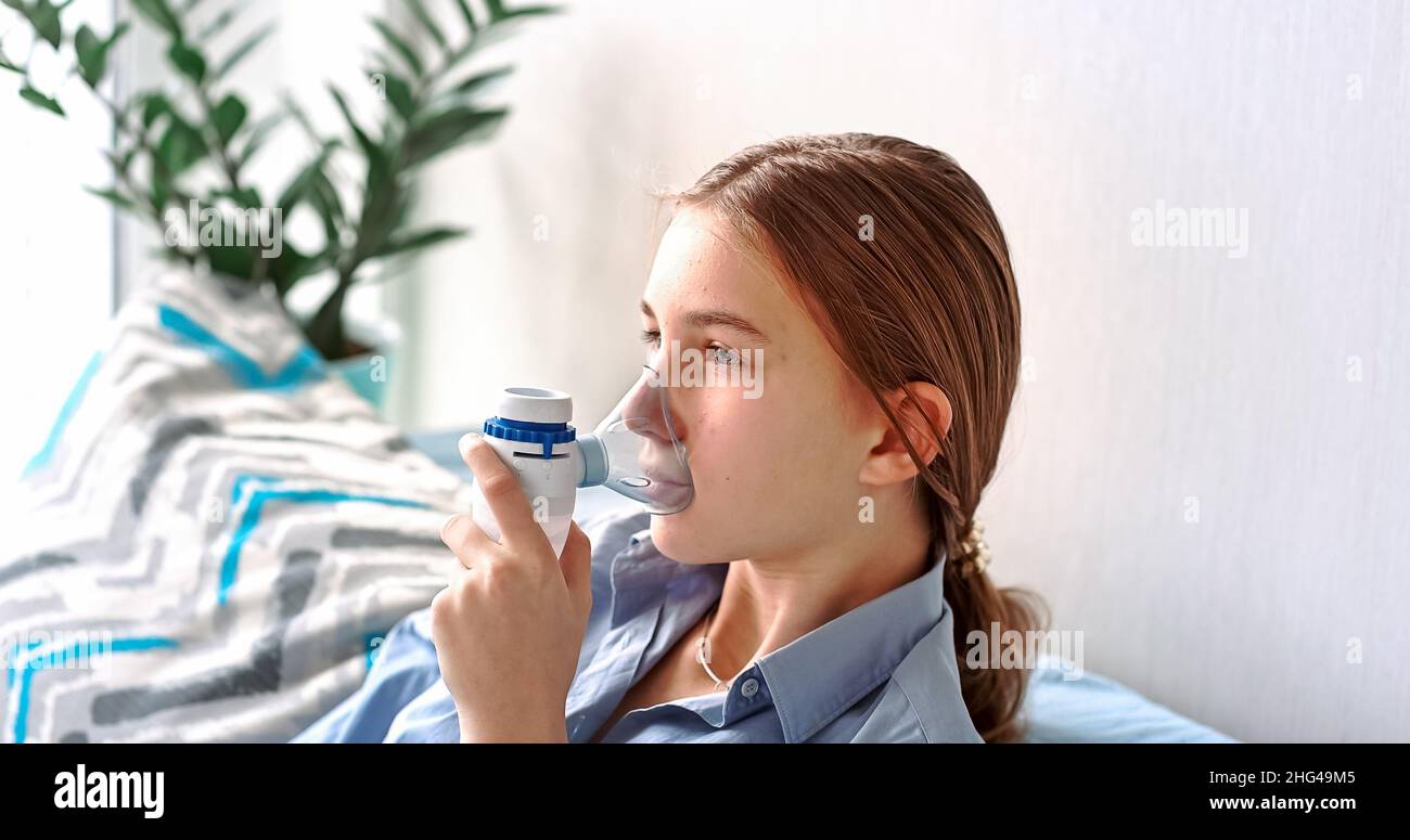 Teenage girl makes inhalation with a nebulizer equipment. Sick child ...