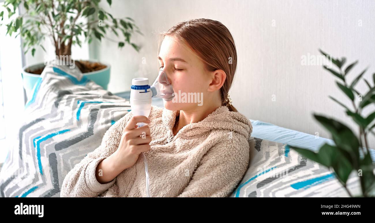 Teenage girl makes inhalation with a nebulizer equipment. Sick child ...