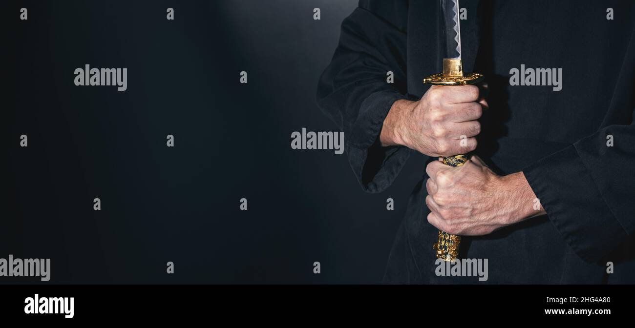 Samurai ready for battle holding a Japanese katana sword, banner. Photo ...