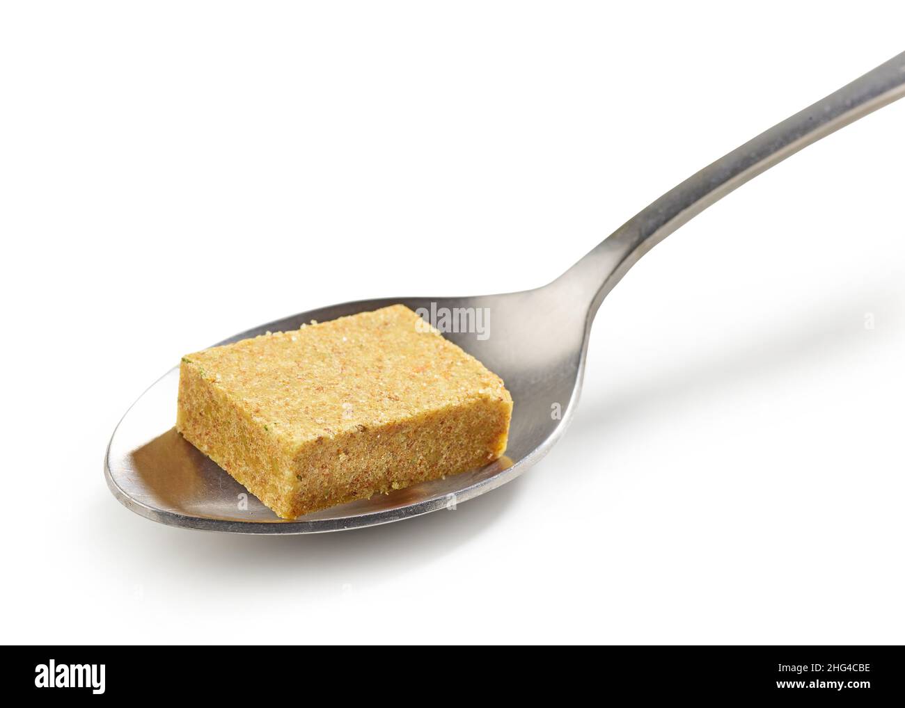 instant chicken broth cube in a spoon isolated on white background ...