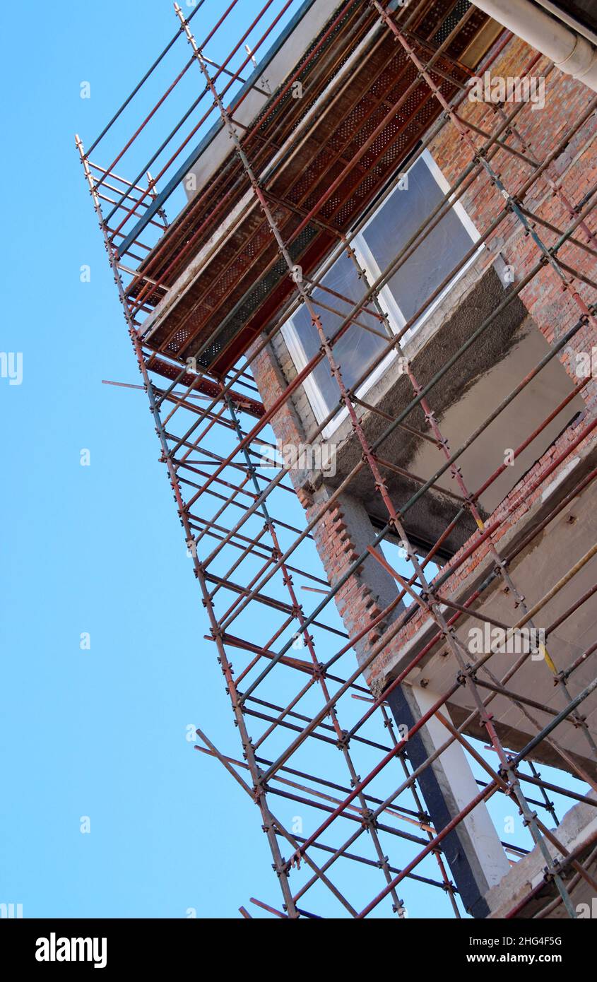Scaffolding attached to the side of a building being constructed Stock ...