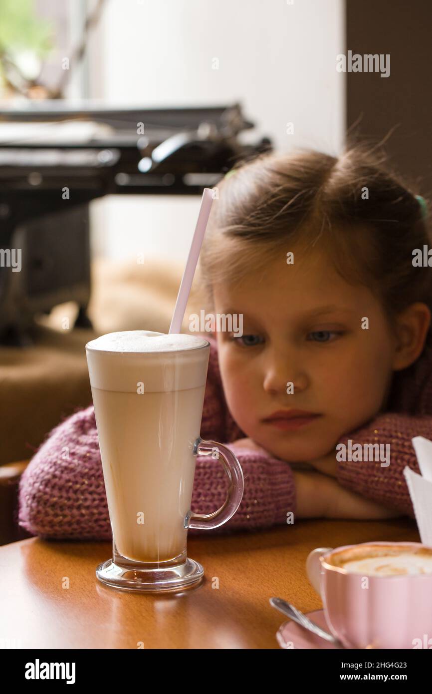 Sad girl in a cafe with a glass of cocoa Stock Photo - Alamy