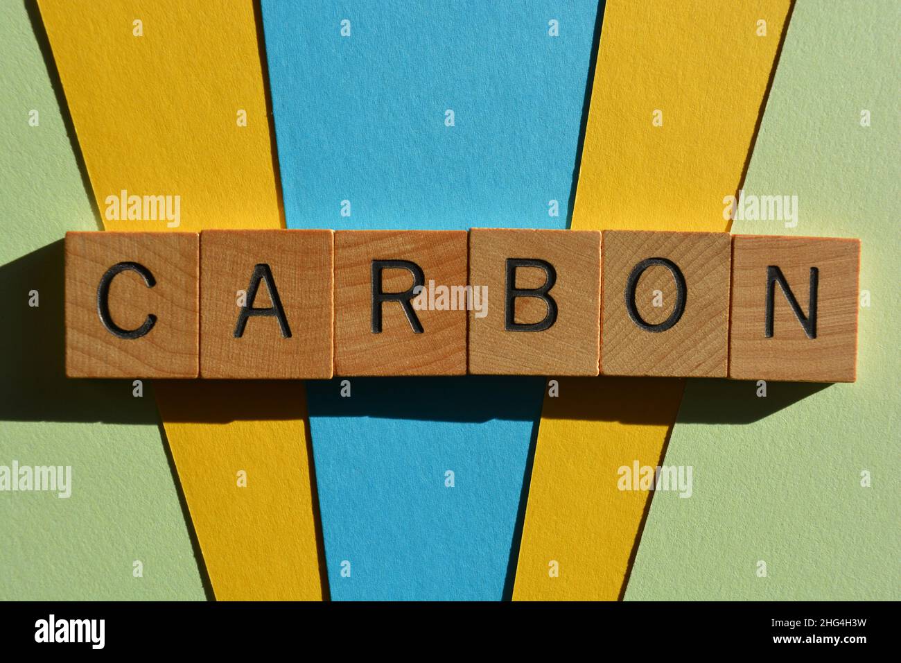 Carbon, word in wooden alphabet letters isolated on blue, yellow and ...