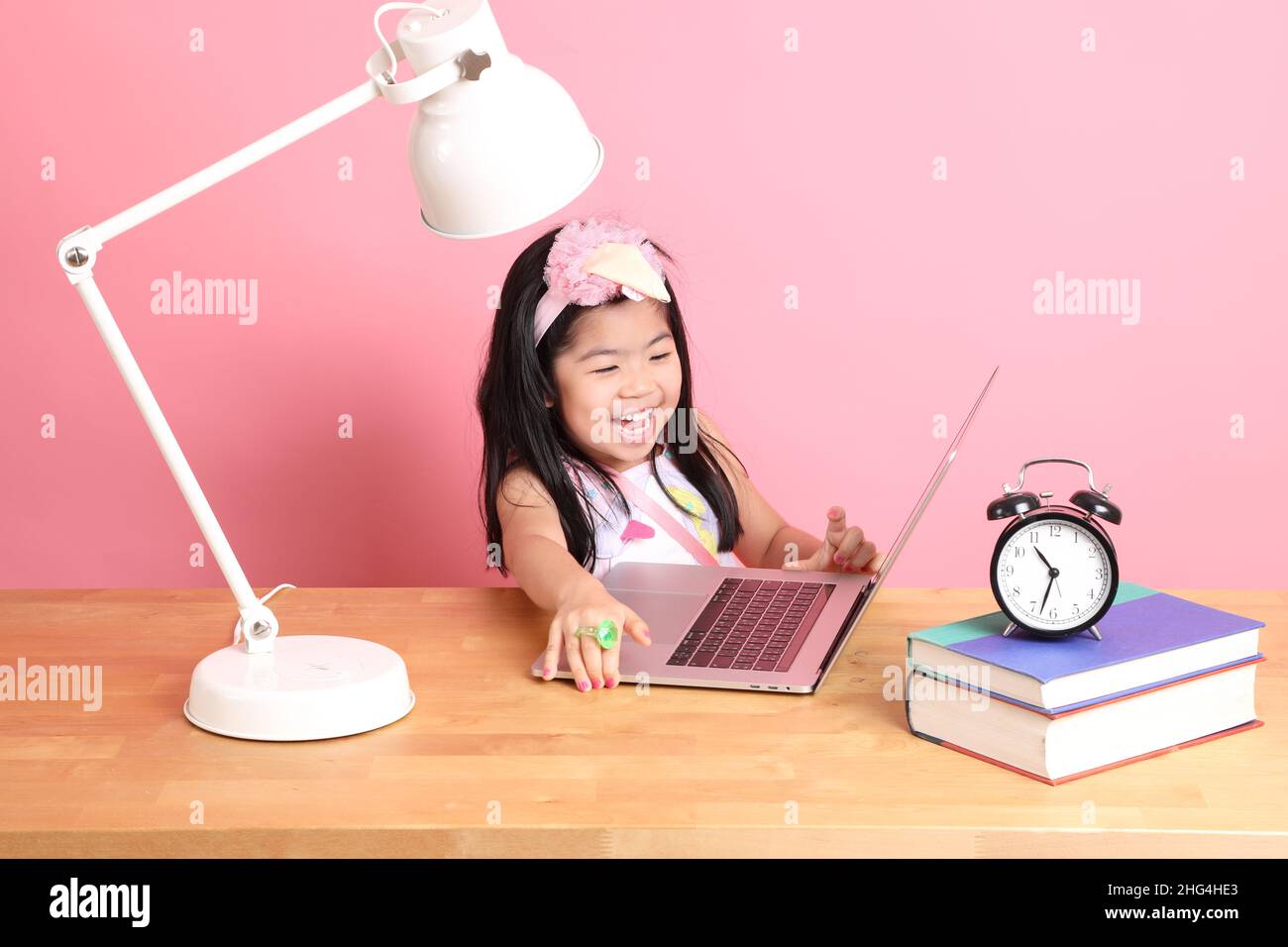 The cute Asian girl learning from internet by laptop with the pink ...