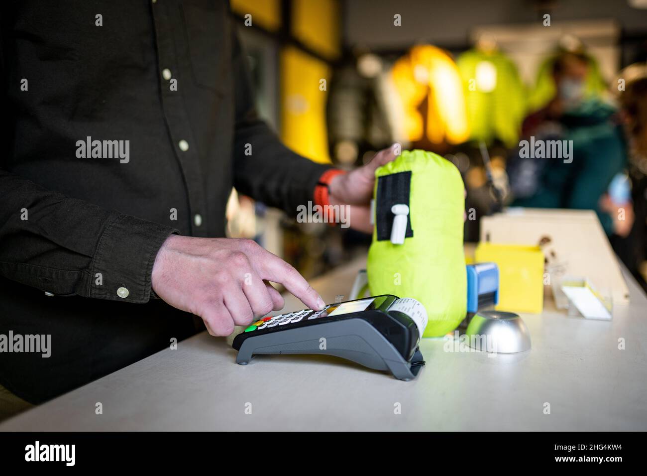 Salesman holds payment terminal while holding receipt for completing ...