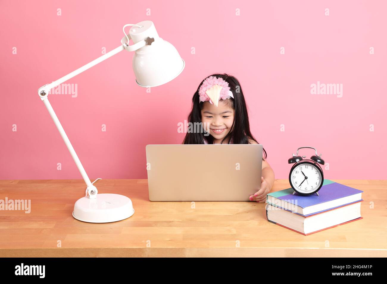 The cute Asian girl learning from internet by laptop with the pink ...