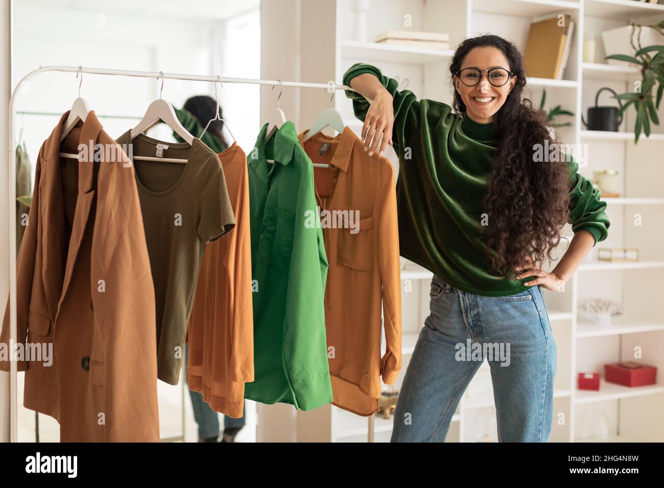 Happy Female Designer Standing Near Clothing Rail In Modern Showroom ...