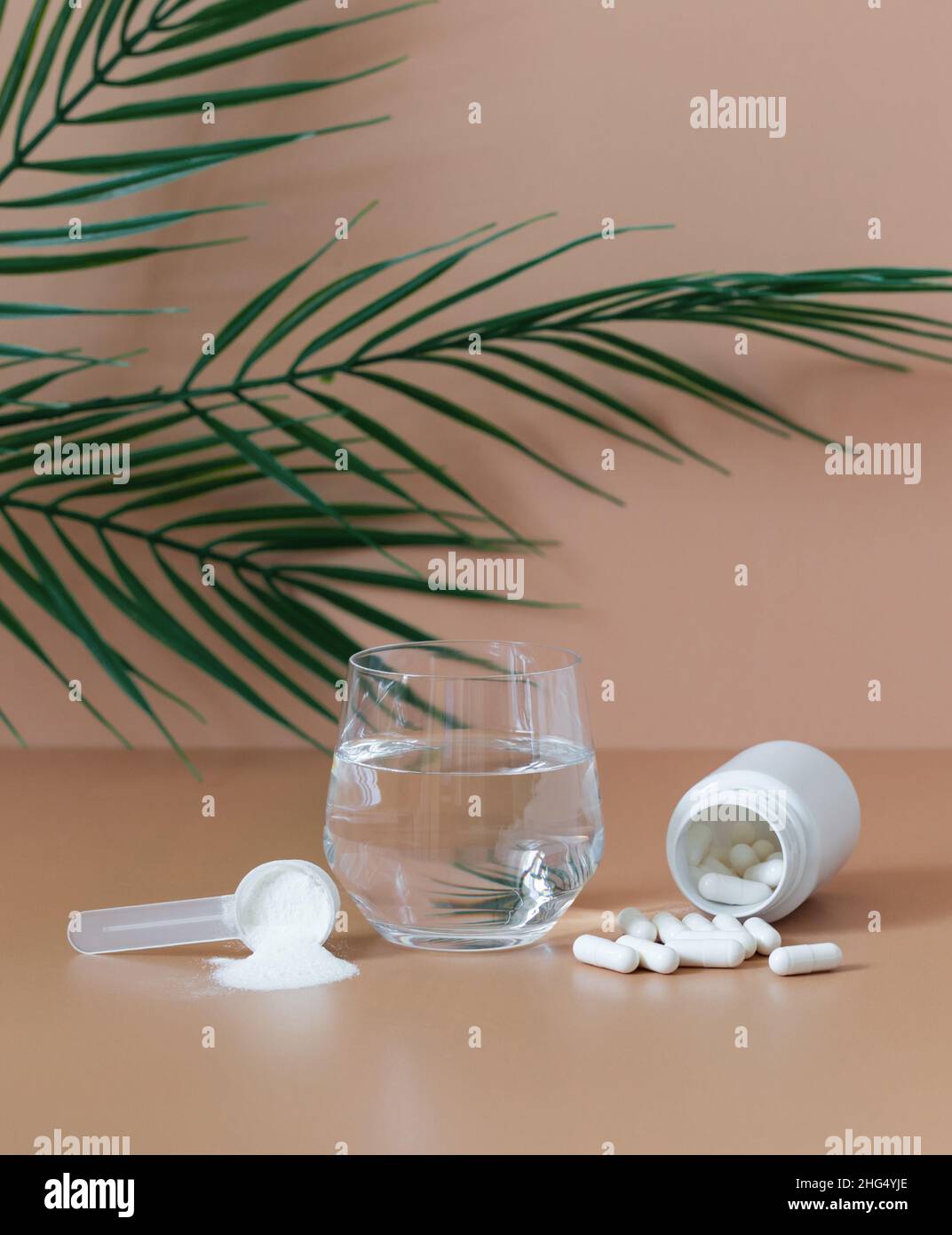 Collagen on a beige background with green leaves. Collagen protein ...