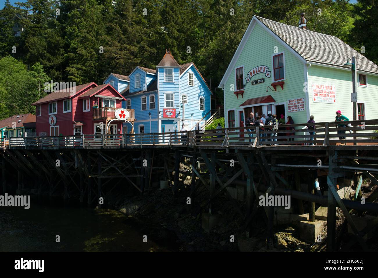 Tourists visiting the local shops along the Ketchikan Creek flowing ...