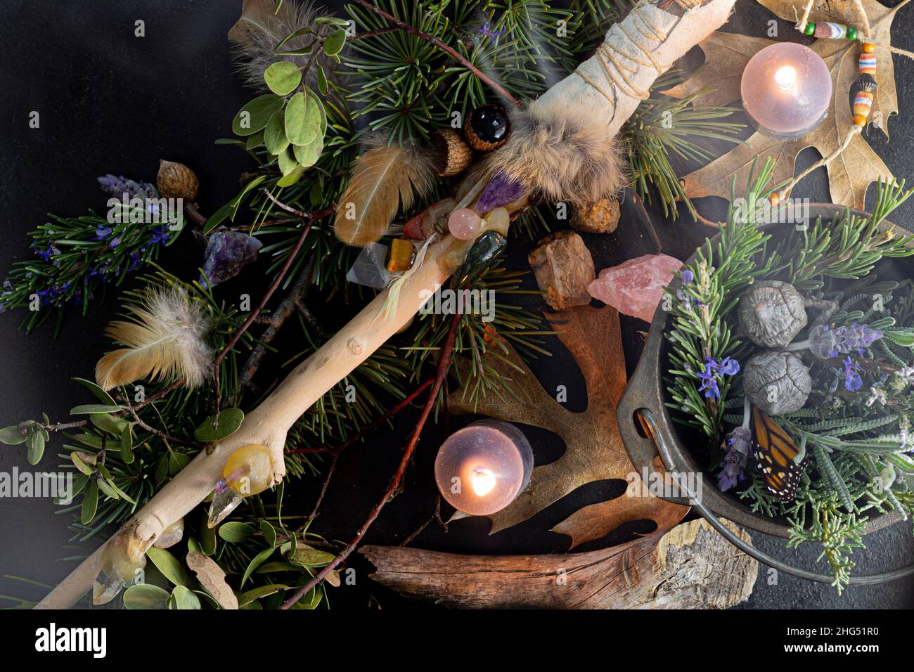 A cauldron full of herbs, a magic wand with crystals, burning candles ...