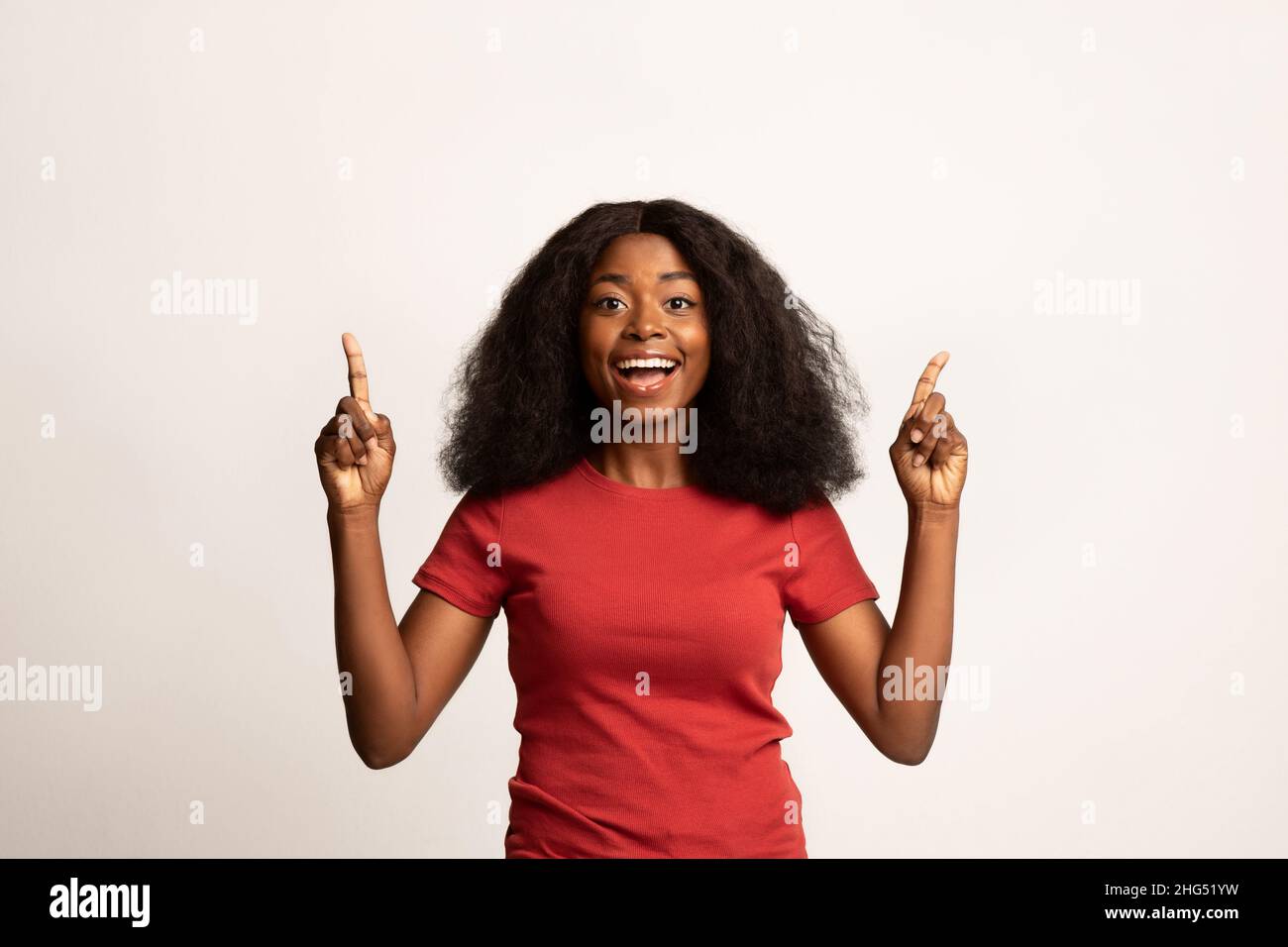 Woman smiling pointing up hi-res stock photography and images - Alamy