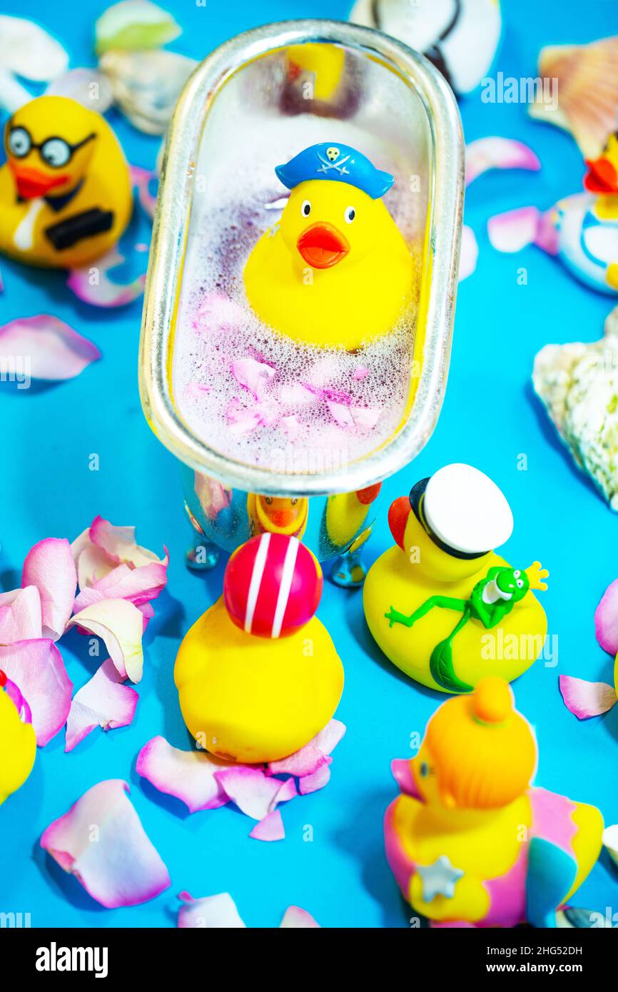 Rubber duck in the bathtub, colorful background with shells, rose ...
