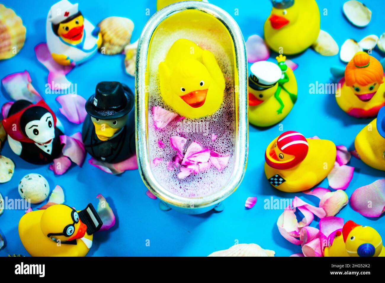 Rubber duck in the bathtub, colorful background with shells, rose ...