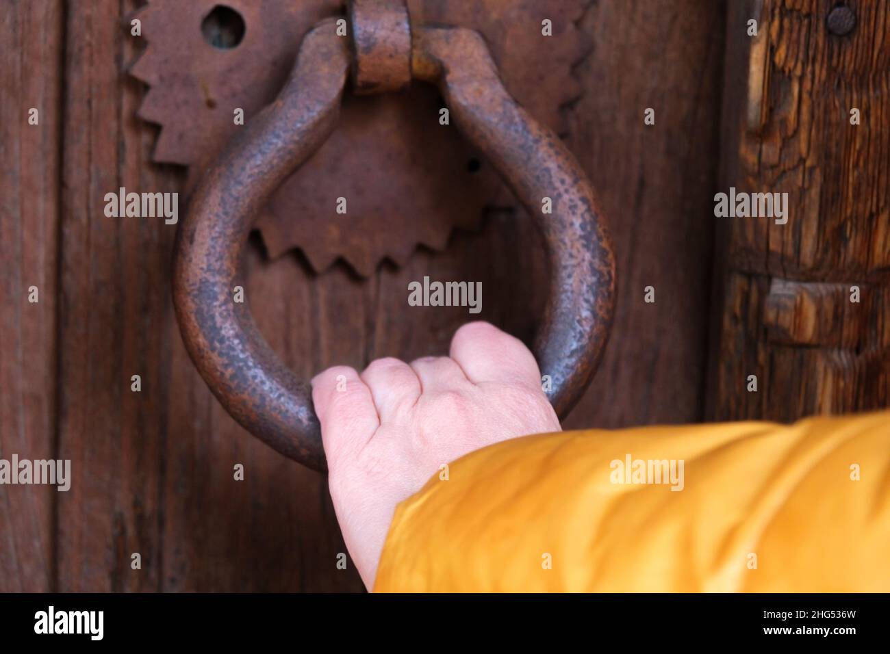 Female hand knocking on the door with ancient iron doorknob, woman ...