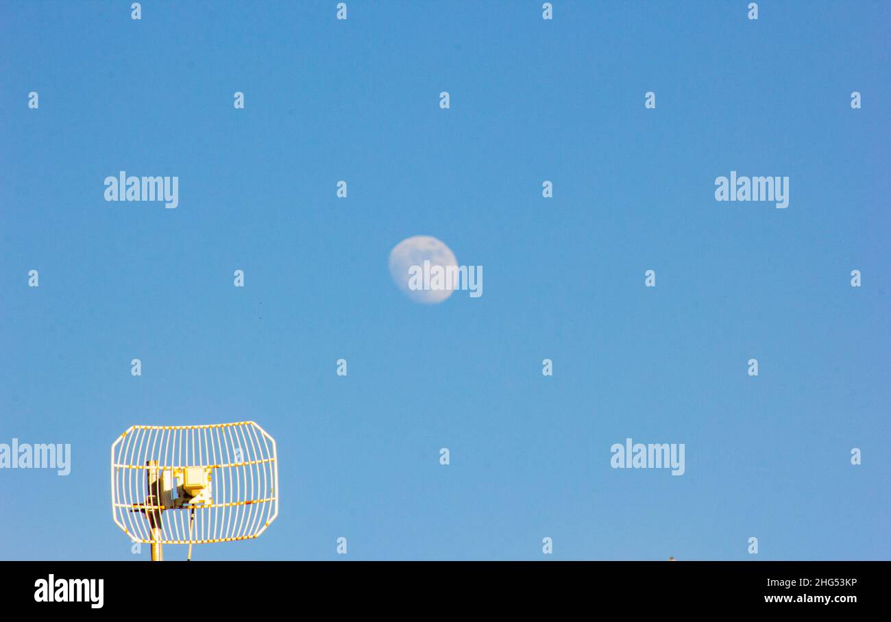 old television antenna with moon in the background and blue sky Stock ...