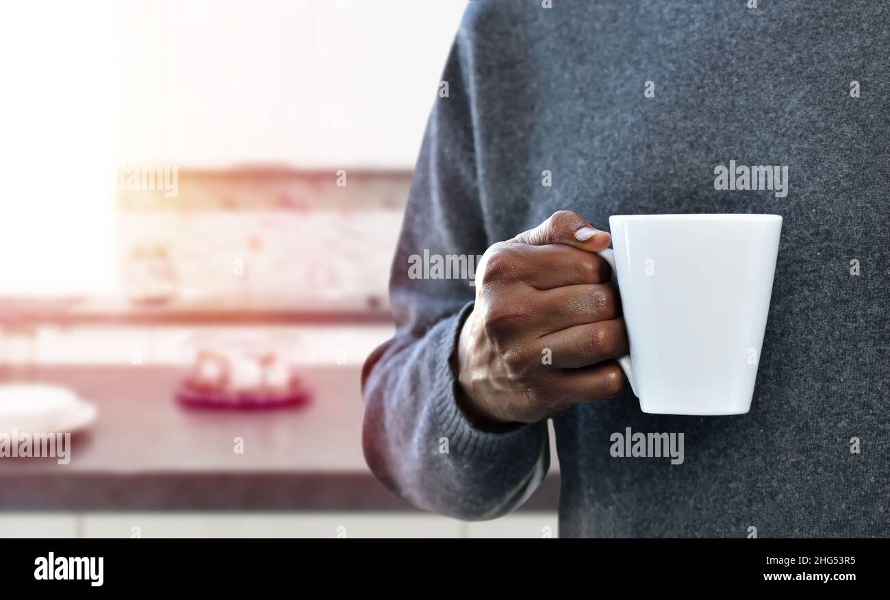 Hand of man holding a coffee cup t kitchen Stock Photo - Alamy