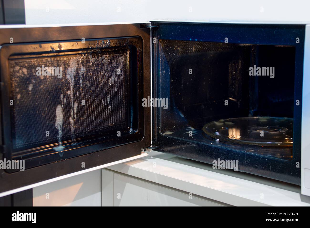 Shot of a door microwave full of dirty at home Stock Photo - Alamy