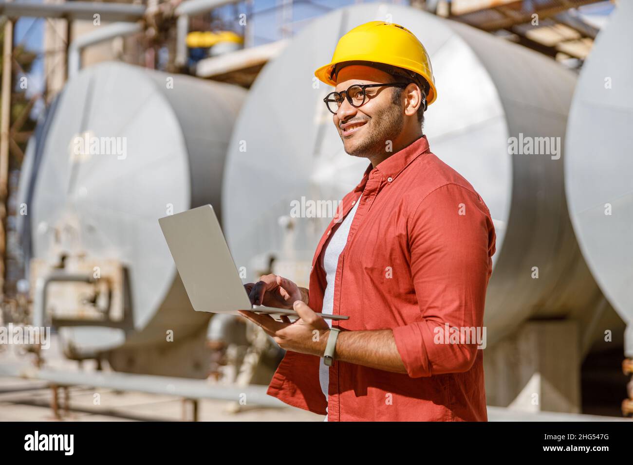 Construction engineer standing against manufacturing facility of plant ...