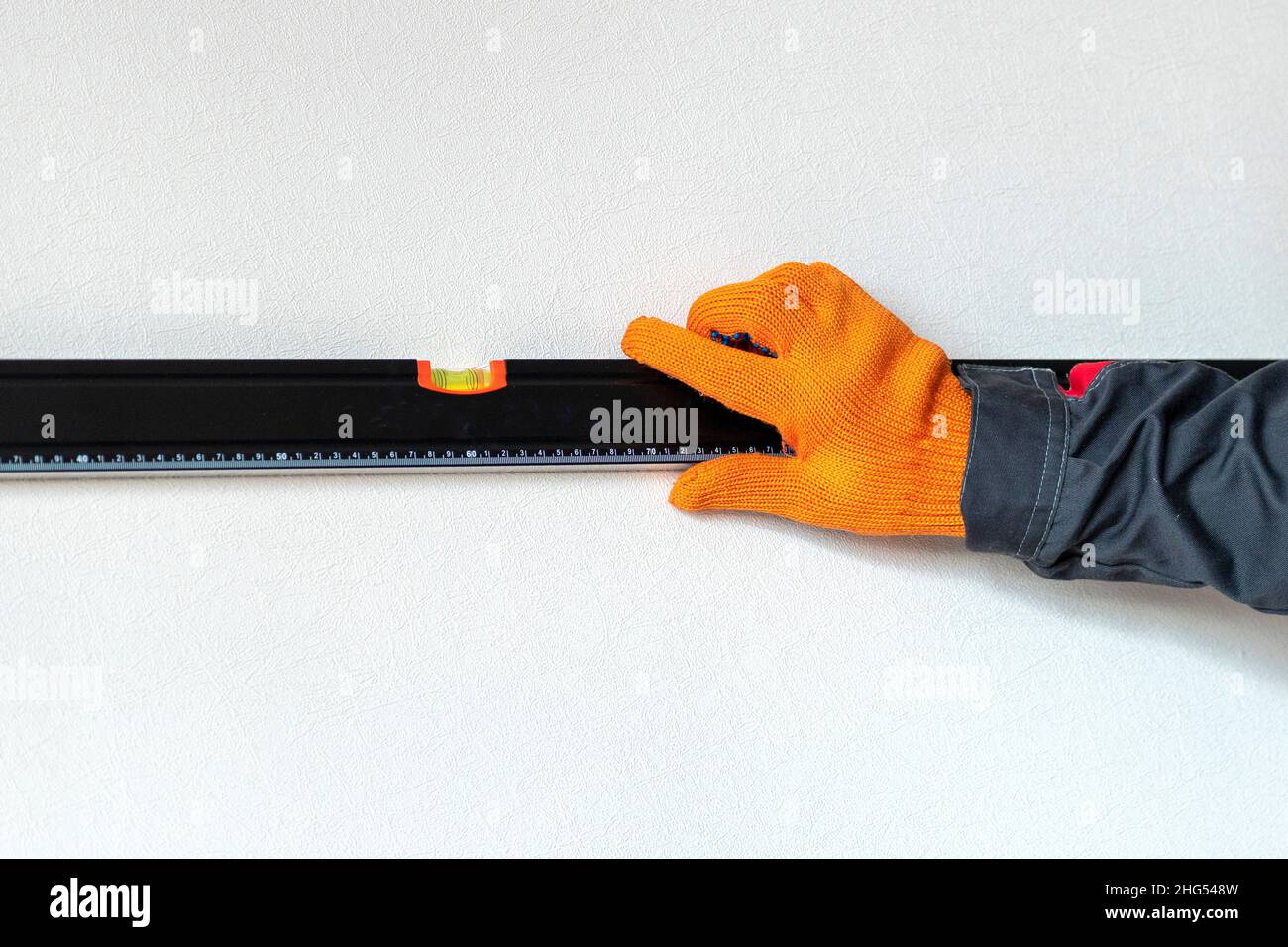 Worker's hands with bubble level. measuring with bubble level ...