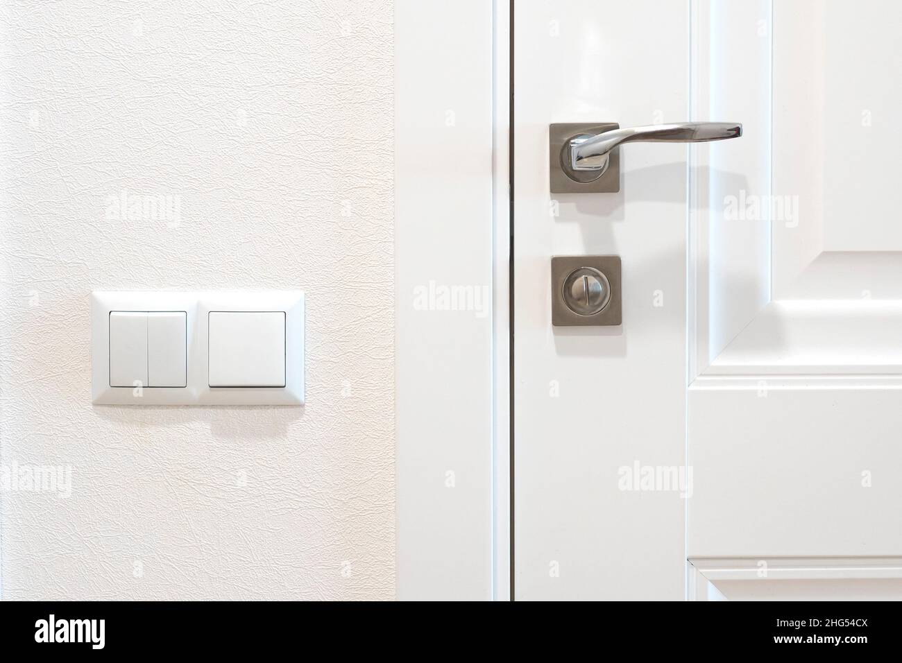 White doors with a handle. Closed door. Two switches Stock Photo - Alamy