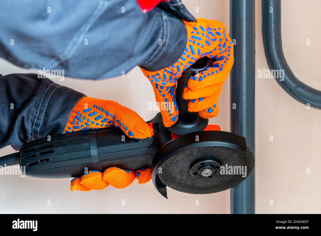 The worker is holding a grinding machine with a disk. Pipe cutting ...