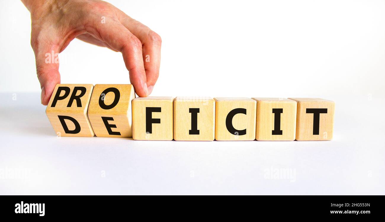 Proficit or deficit symbol. Businessman turns cubes, changes the word deficit to proficit ...