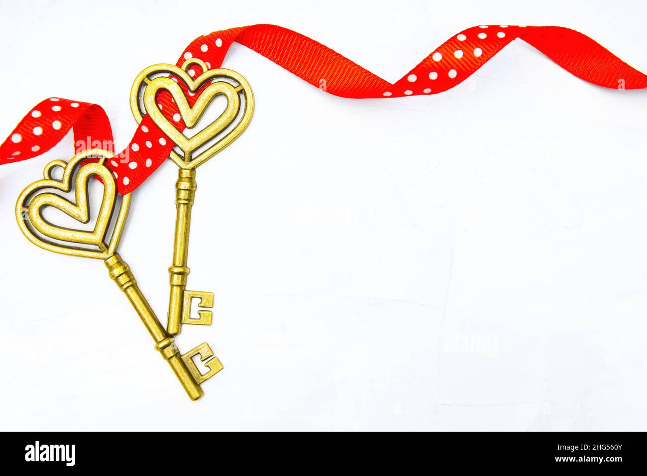 Close-up of two skeleton keys wrapped together with a red dotted ribbon ...