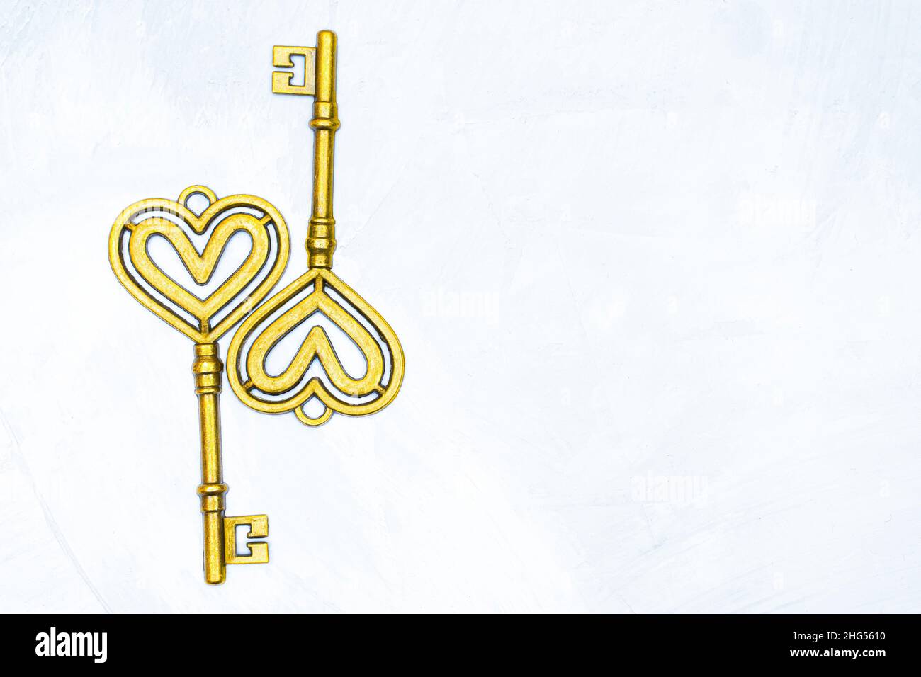 Two antique style heart shaped keys on a neutral background with copy ...