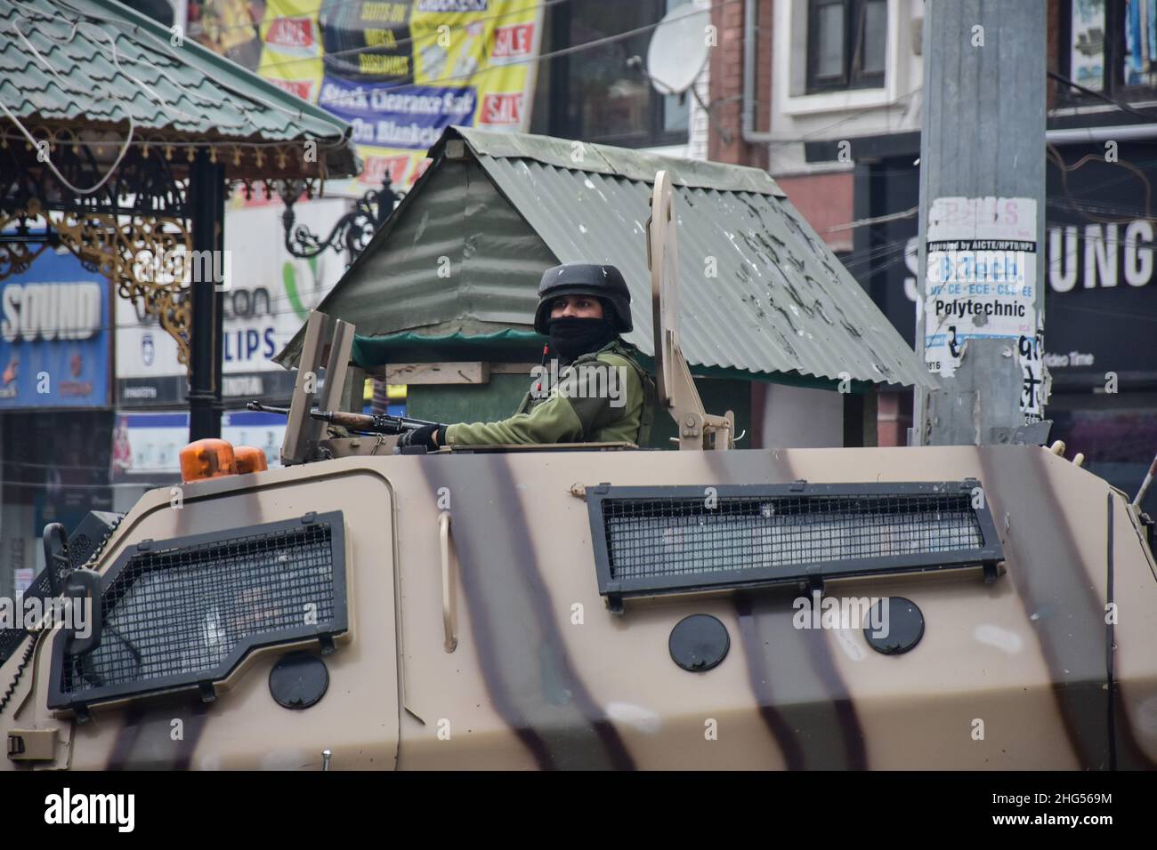 A paramilitary trooper takes position on top of his armored vehicle ...