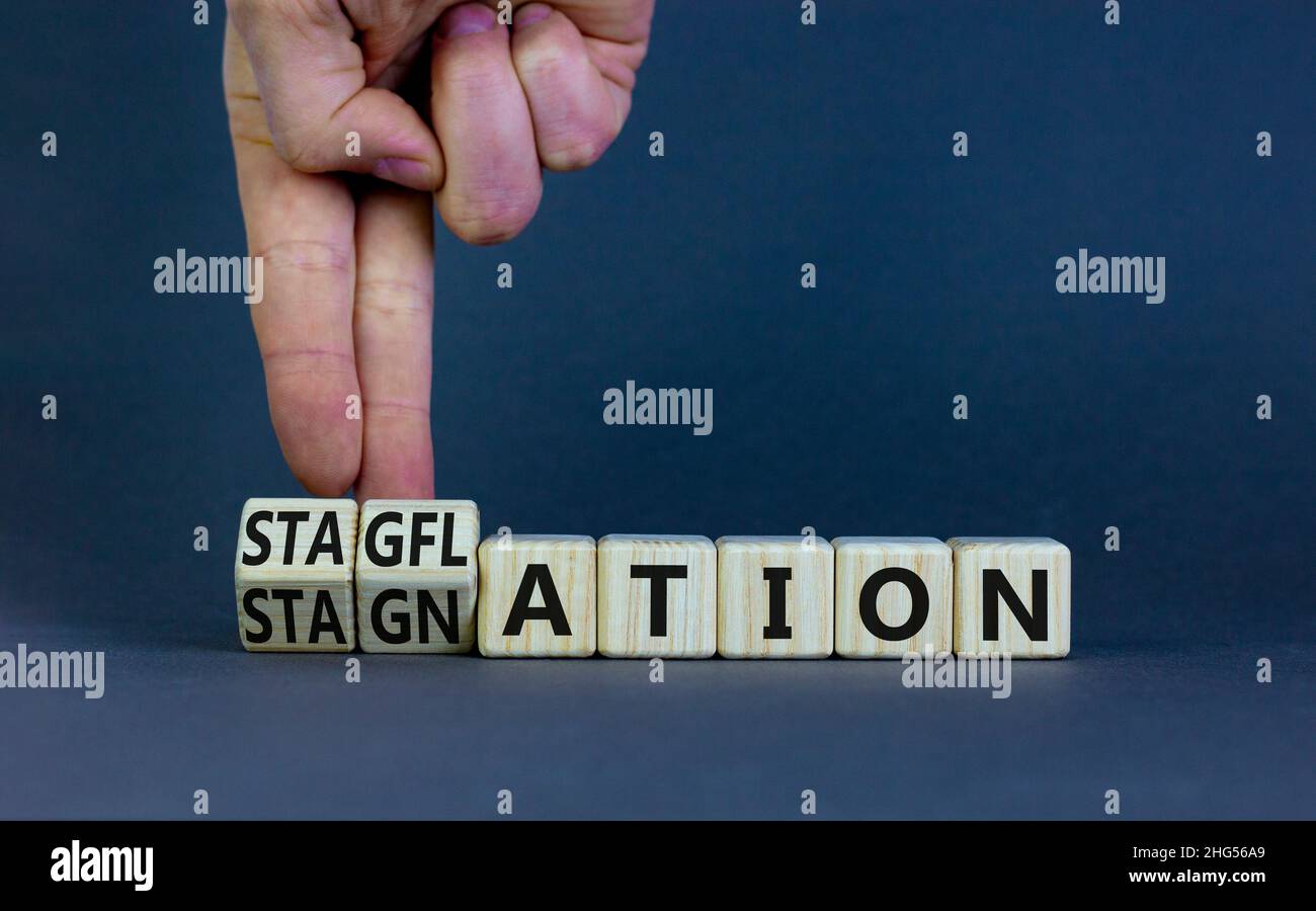 Stagflation or stagnation symbol. Businessman turns cubes, changes the ...
