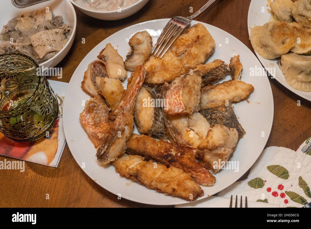 The Wigilia table is set with a white tablecloth under which is placed ...
