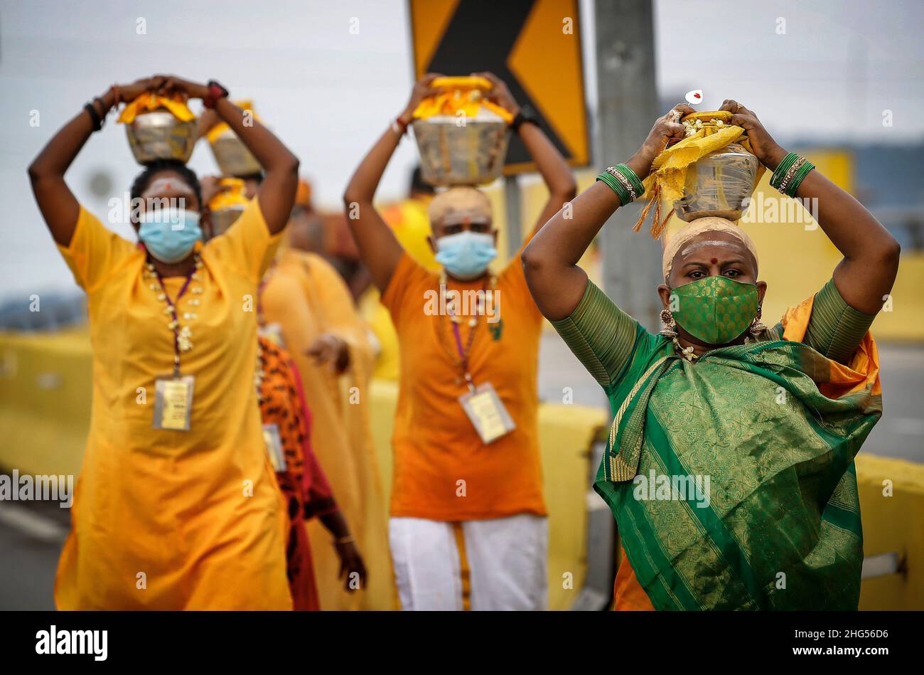 Hindu devotees carry milk pots on their heads in a procession during ...