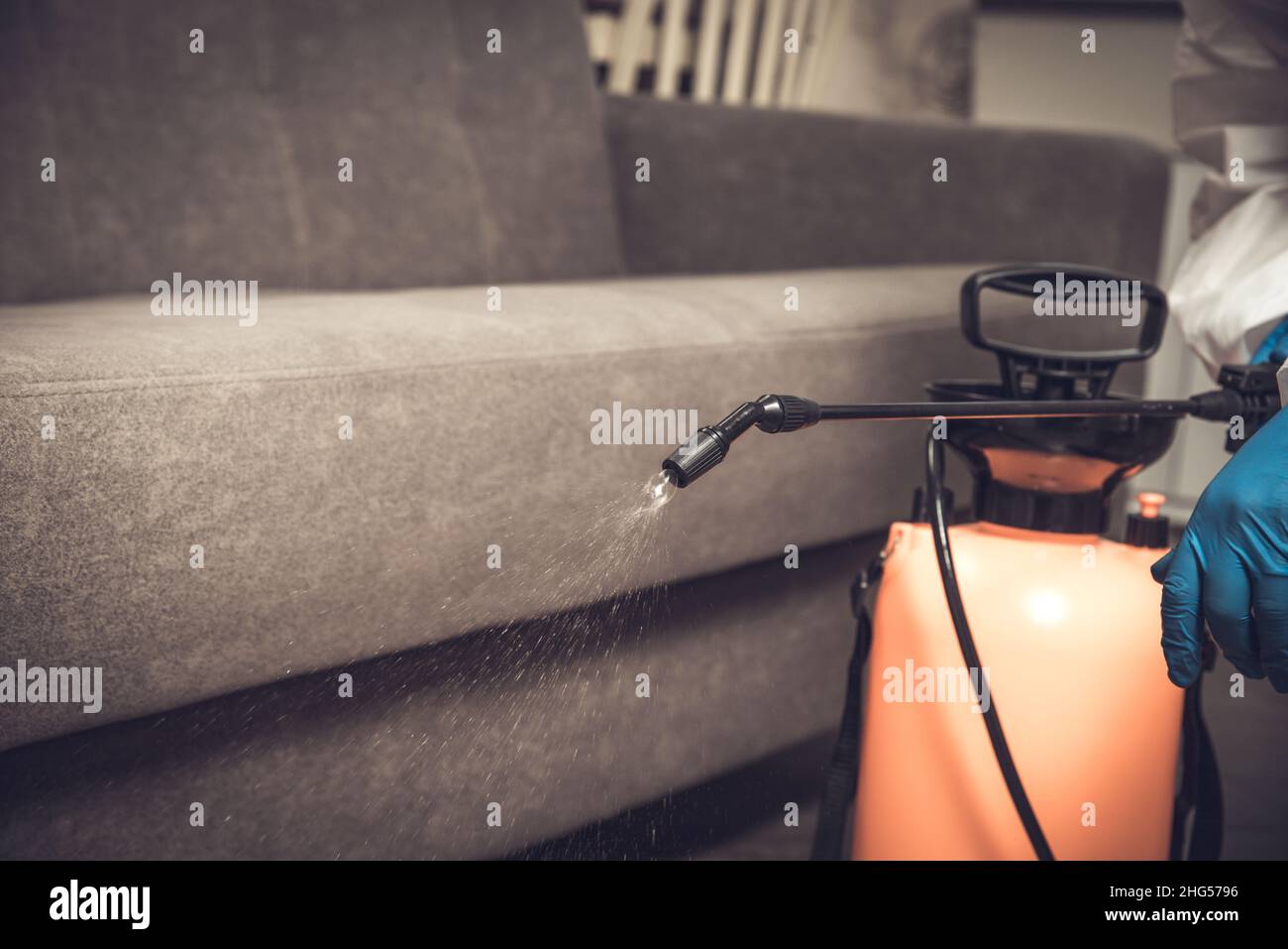 Spray gun with pesticides close-up. An exterminator in work clothes ...