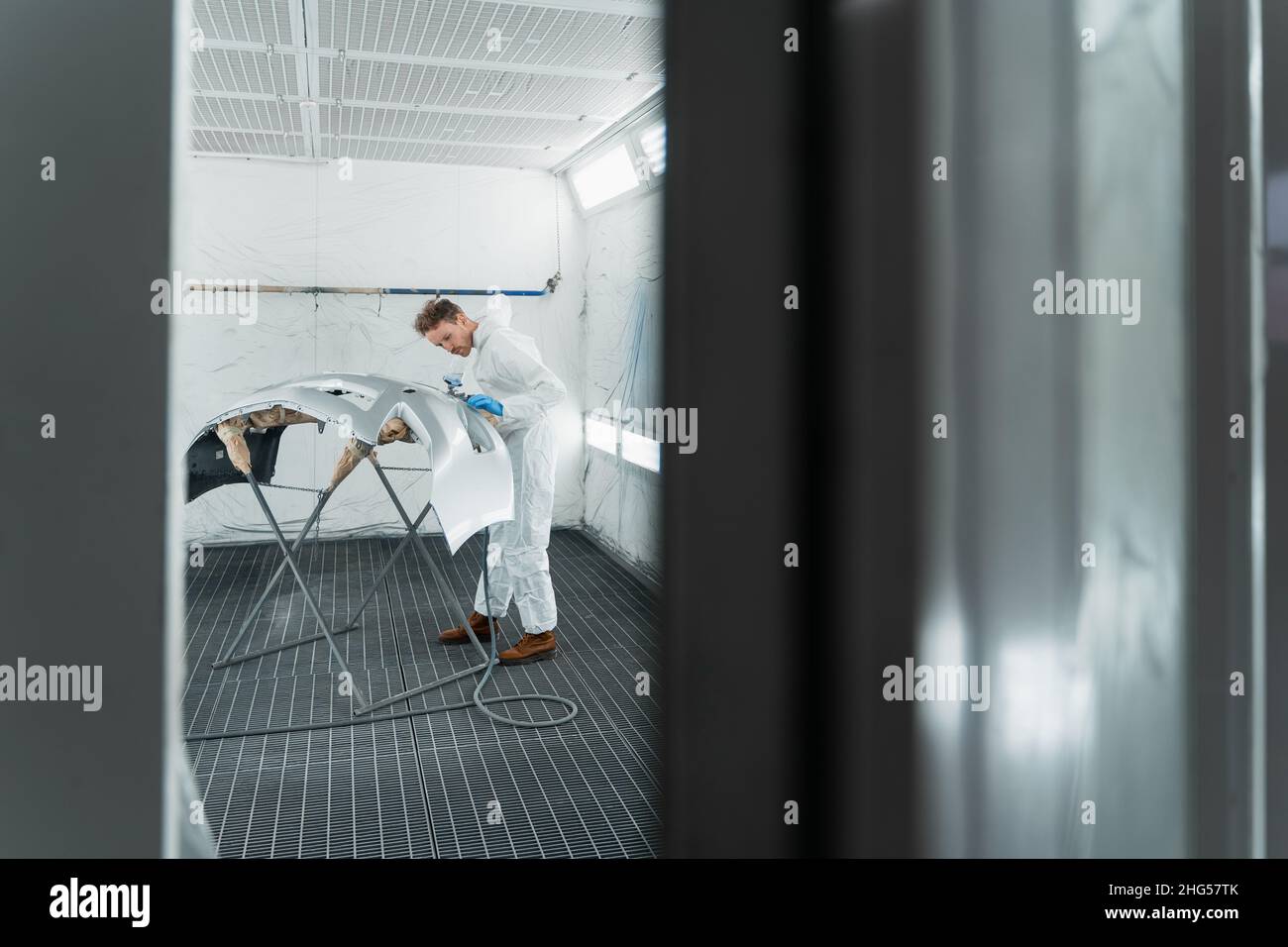 Repairman car painter in chamber painting automobile bumper Stock Photo ...