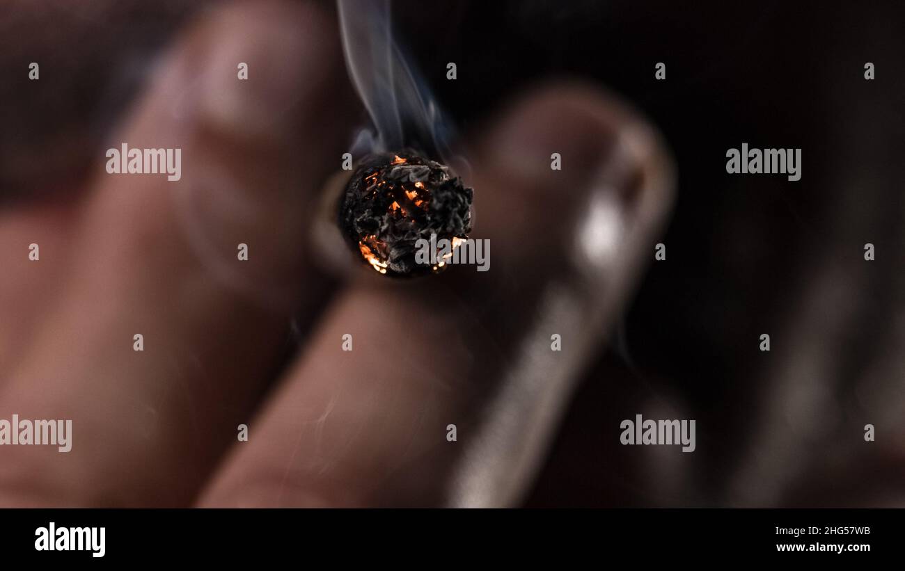 Smoking marijuana joint. Cannabis cigarette burning and a smoke cloud Stock Photo - Alamy
