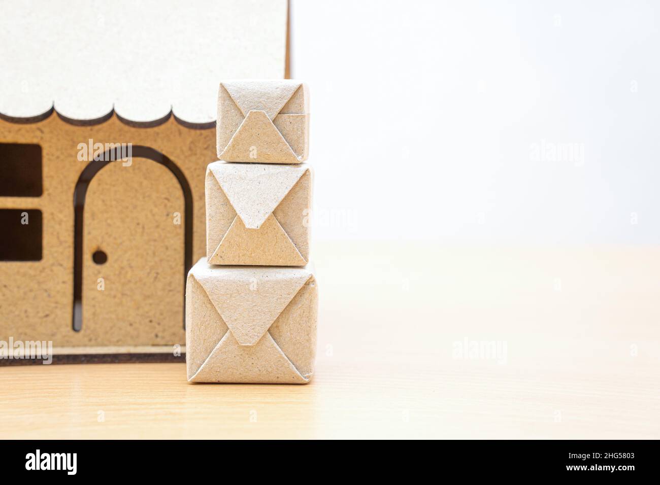 Stack of small packages in front of a miniature house model. Sopping ...
