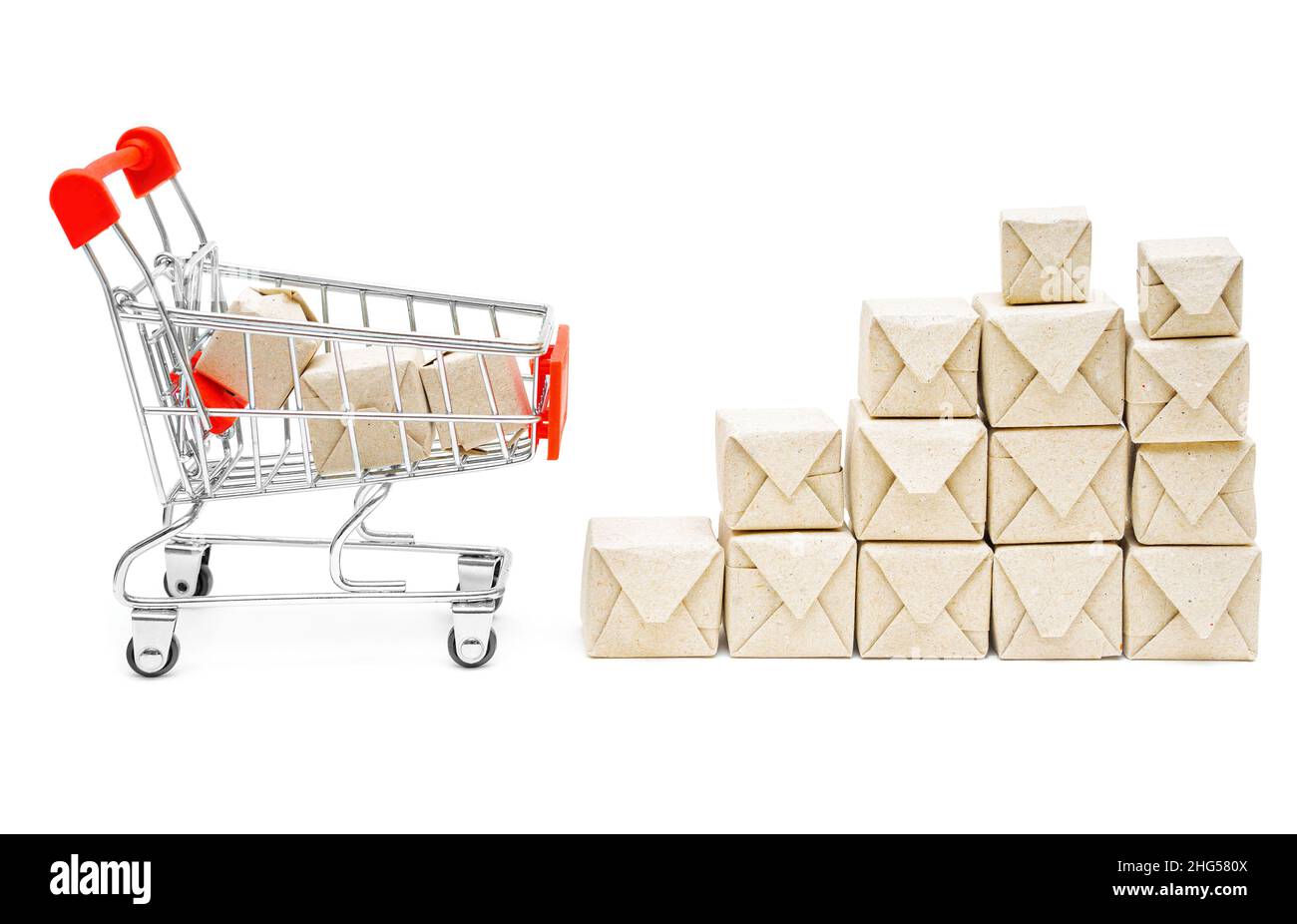 Miniature shopping trolley by a stack of tiny cardboard boxes isolated ...