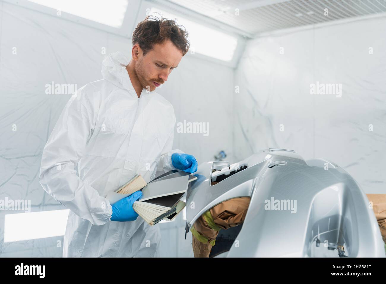 Car painter choosing color shade for automobile body element Stock ...