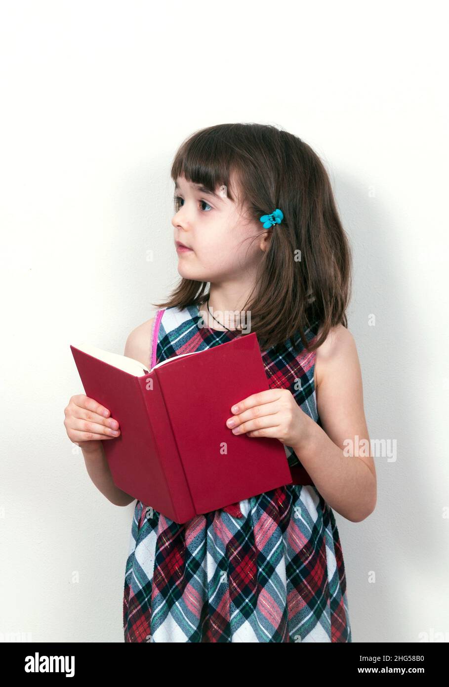 Little girl reading a book at home Stock Photo - Alamy