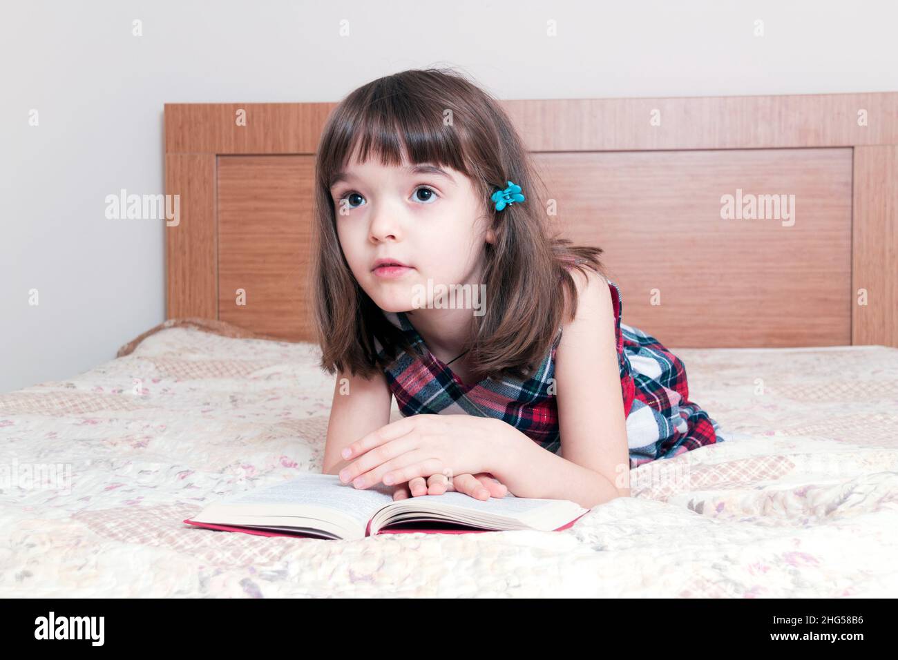 Little girl reading a book at home Stock Photo - Alamy