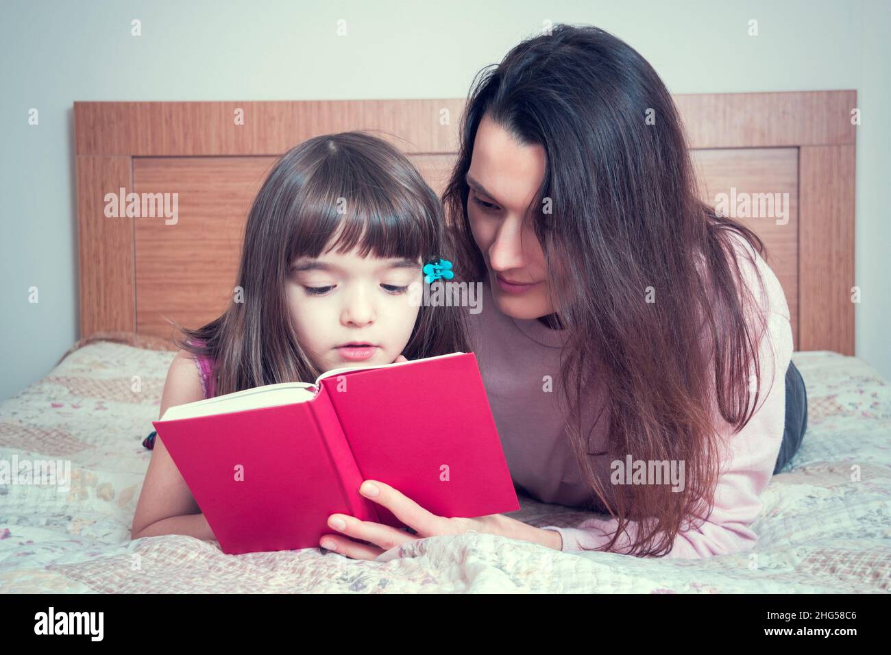 Mom with the daughter reading together Stock Photo - Alamy