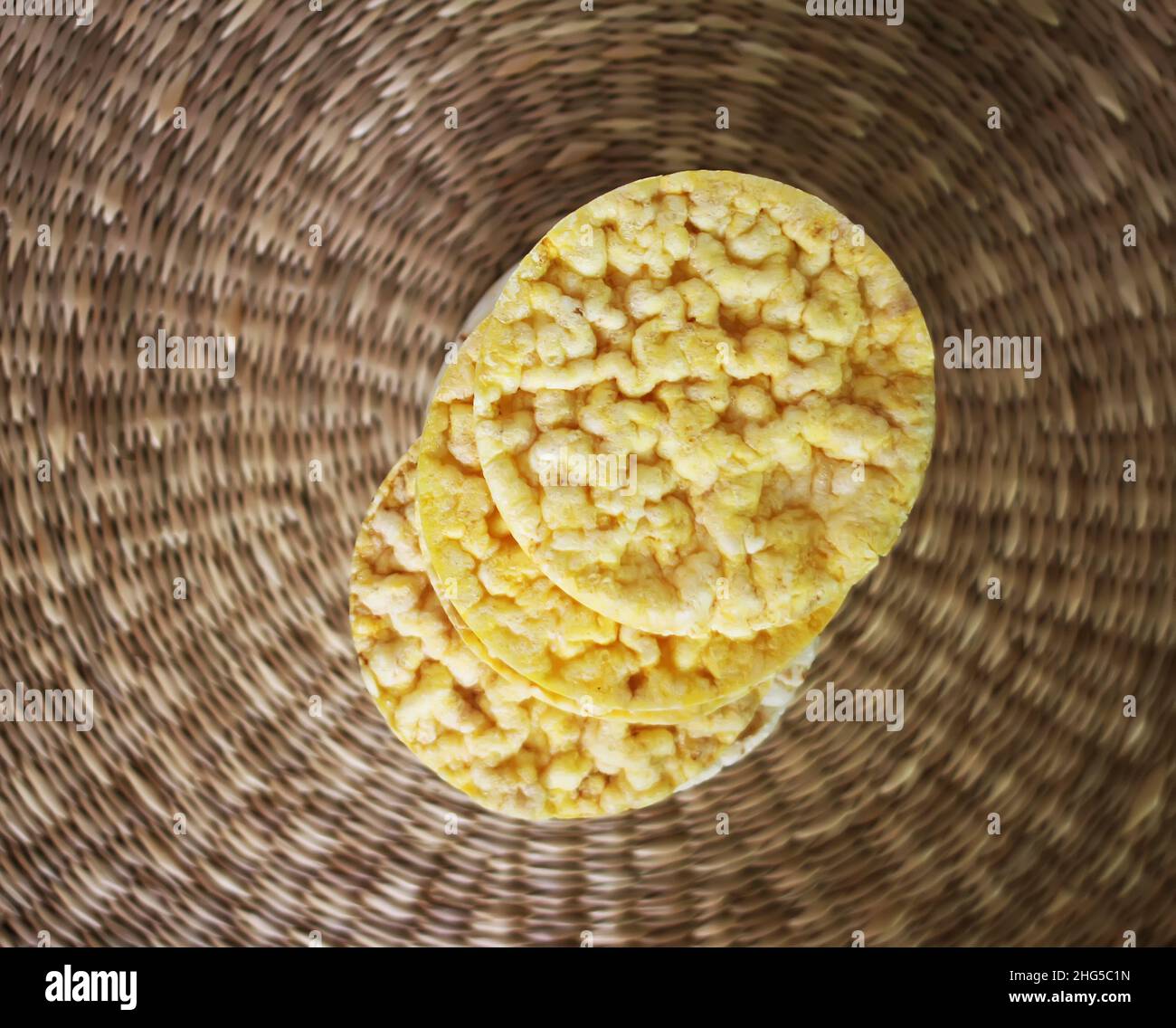 Yellow flat round corn crackers on whicker place mat background Stock ...