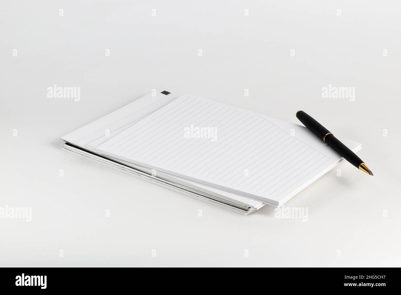 Luxury black ball pen on pile of notebook isolated on white background ...