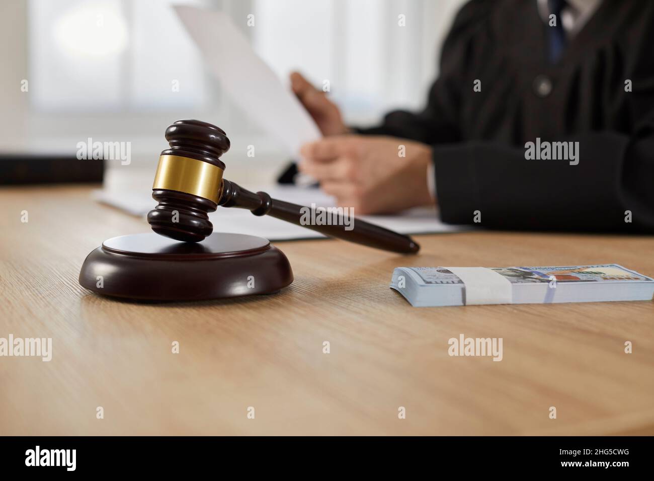 Close up of judge gavel standing on sound block and bundle of dollars ...