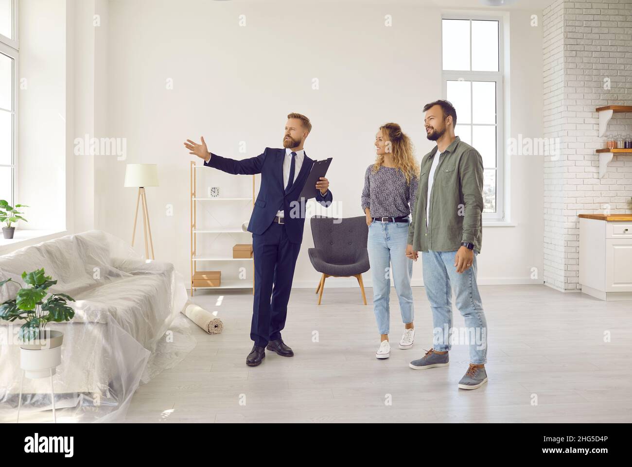 Real estate agent giving tour about rooms to couple who are planning to ...