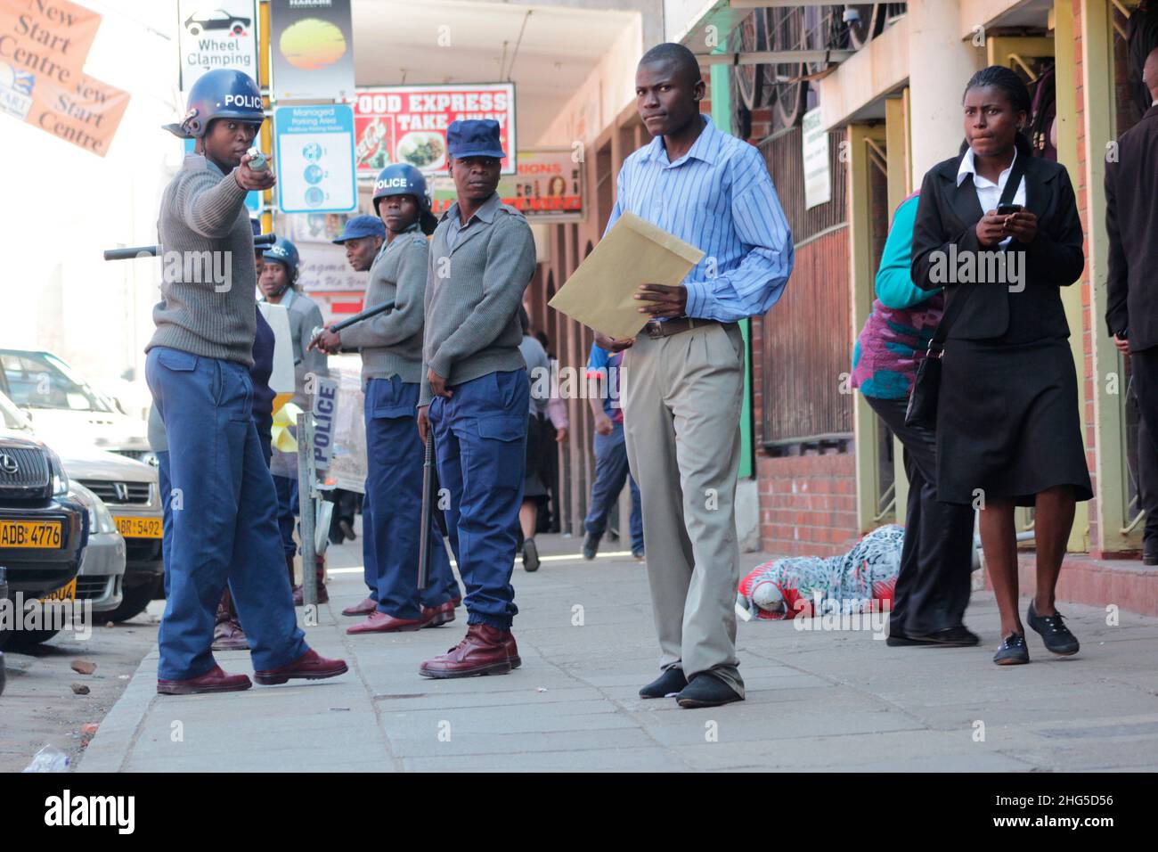 Police officers threaten the photographer taking this image in Harare ...
